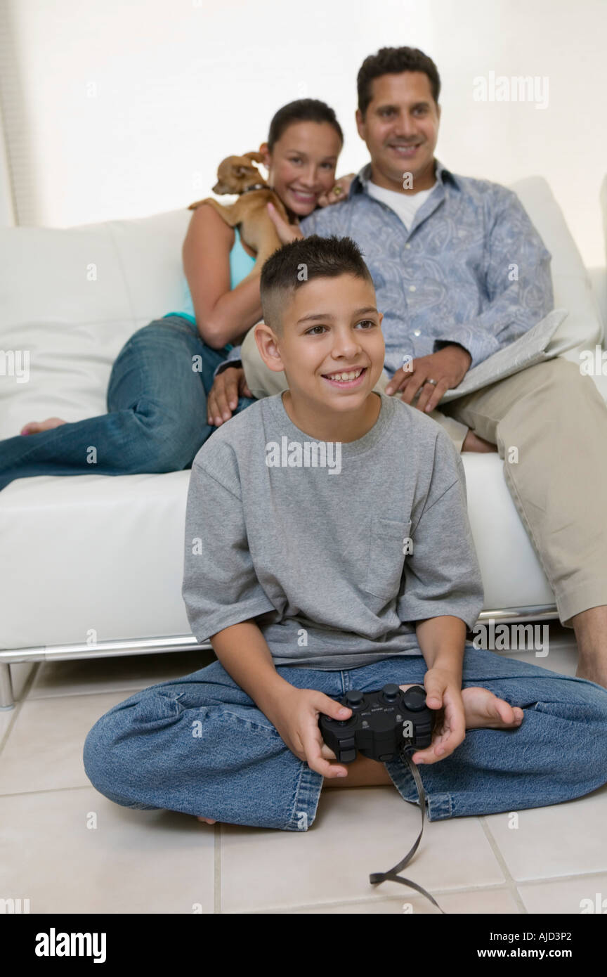 Parents Watching Son Play Video Games in living room, front view Stock ...