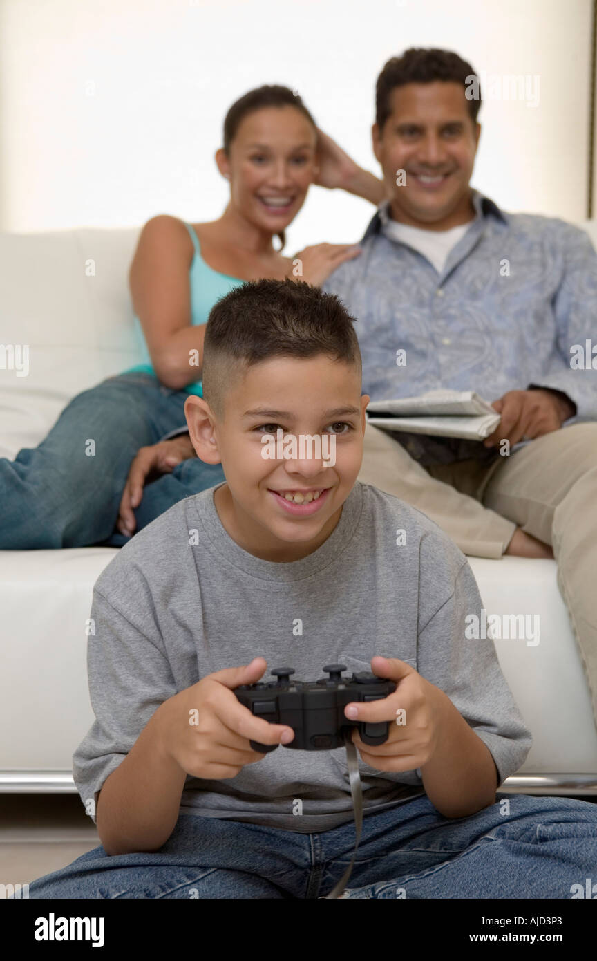 Parents Watching Son Play Video Games in living room, front view Stock ...