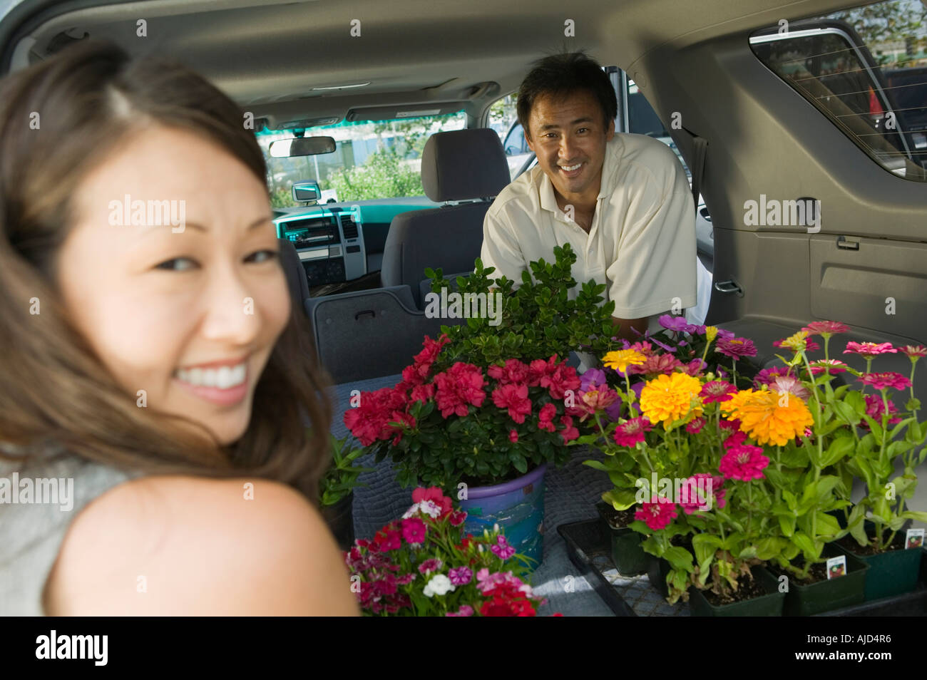 Couple Loading flowers into back of SUV, portrait Stock Photo - Alamy