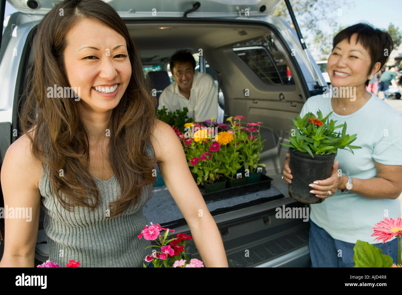 Family loading flowers into back of SUV, portrait Stock Photo - Alamy