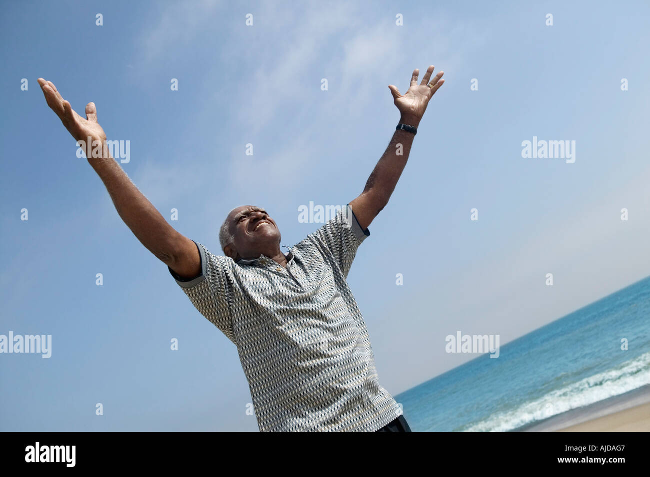 Man with arms outstretched at beach Stock Photo - Alamy