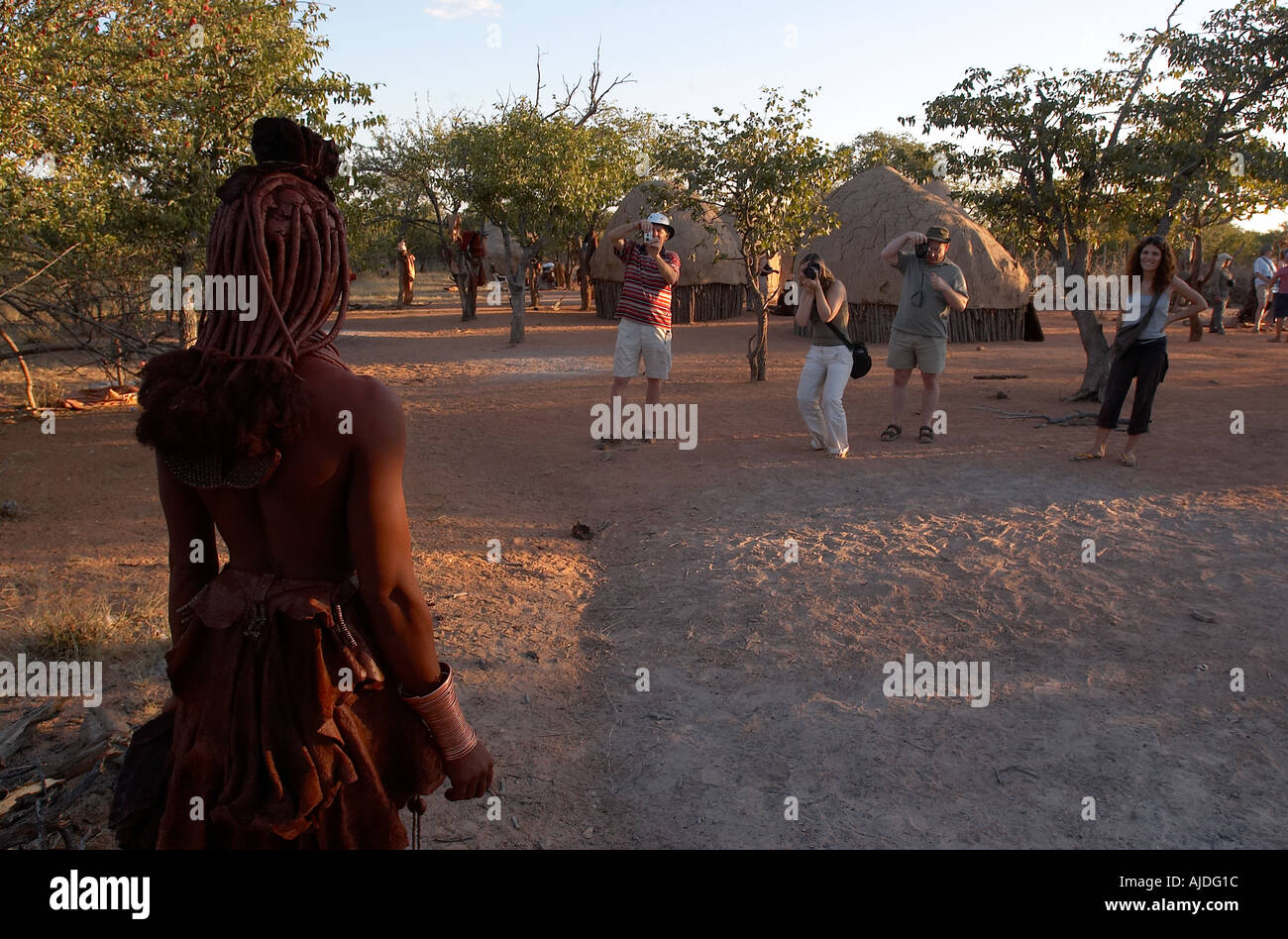 Tourists photographing a Himba women covered in Ochre and clay otjize ...