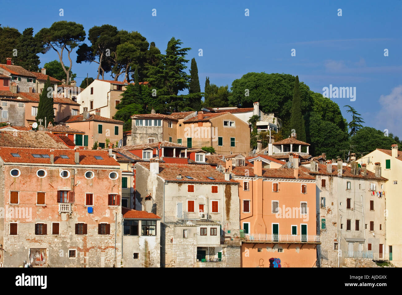 Pastel colored buildings line the rocky shores of Rovinj which sits on ...