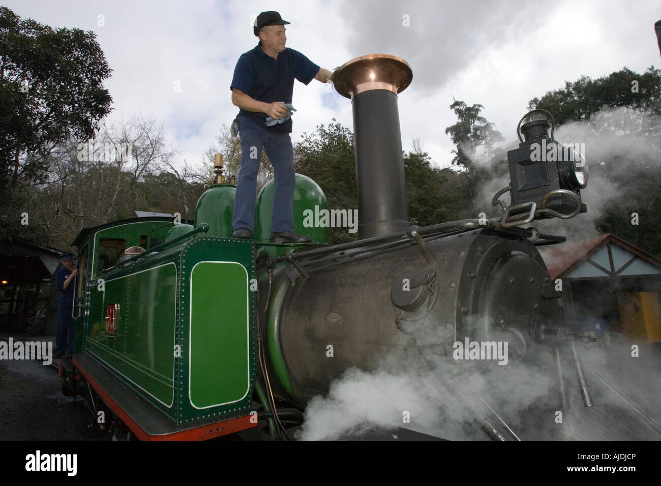Driver polishes locomotive funnel Puffing Billy historic steam railway Melbourne Australia Stock ...