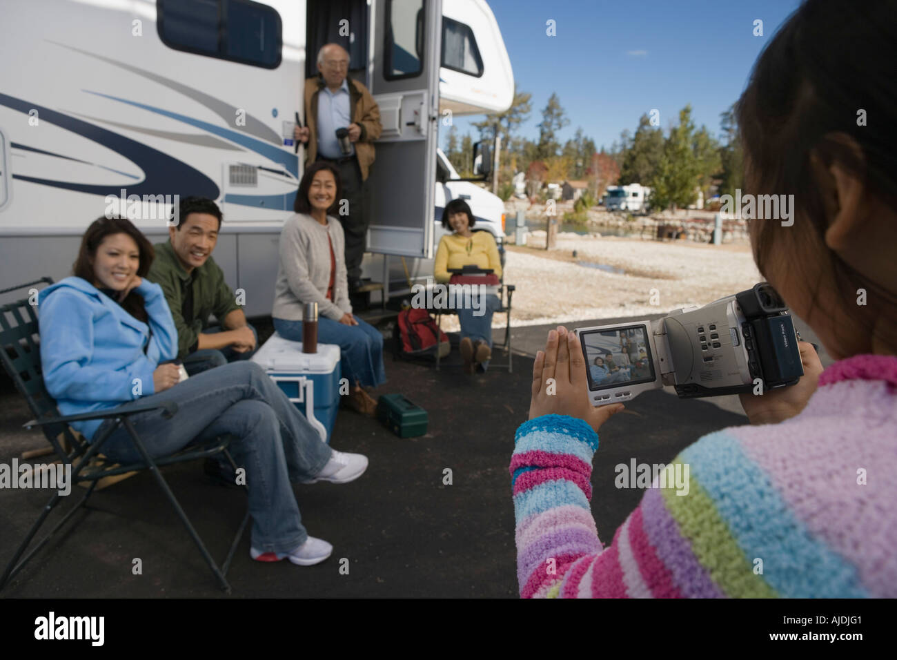 Girl videotaping family outside of RV Stock Photo - Alamy
