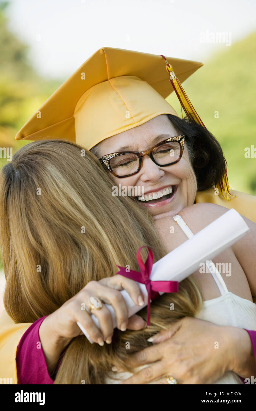 Middle-aged graduate hugging daughter outside Stock Photo - Alamy
