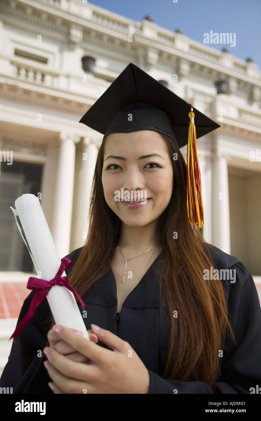 Graduate holding diploma outside university, portrait Stock Photo - Alamy