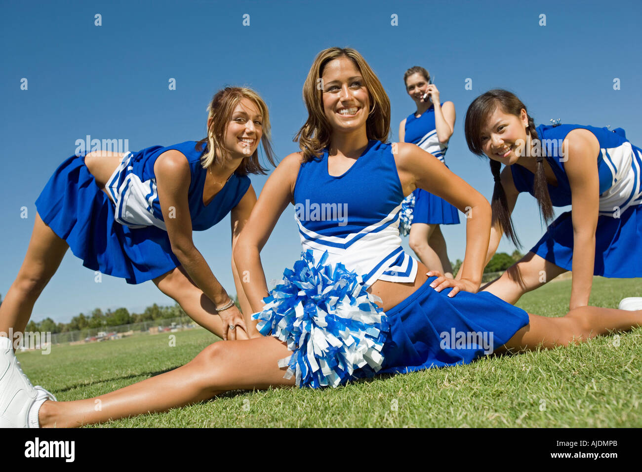 Cheerleaders stretching on lawn, (portrait Stock Photo - Alamy