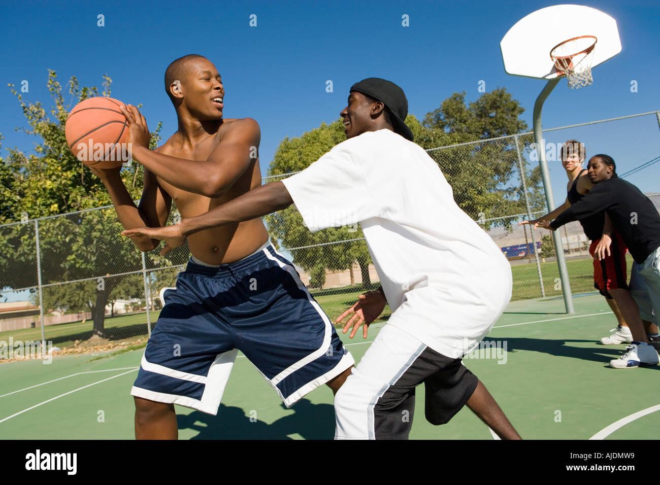 Basketball player trying to guard another as he passes ball Stock Photo ...