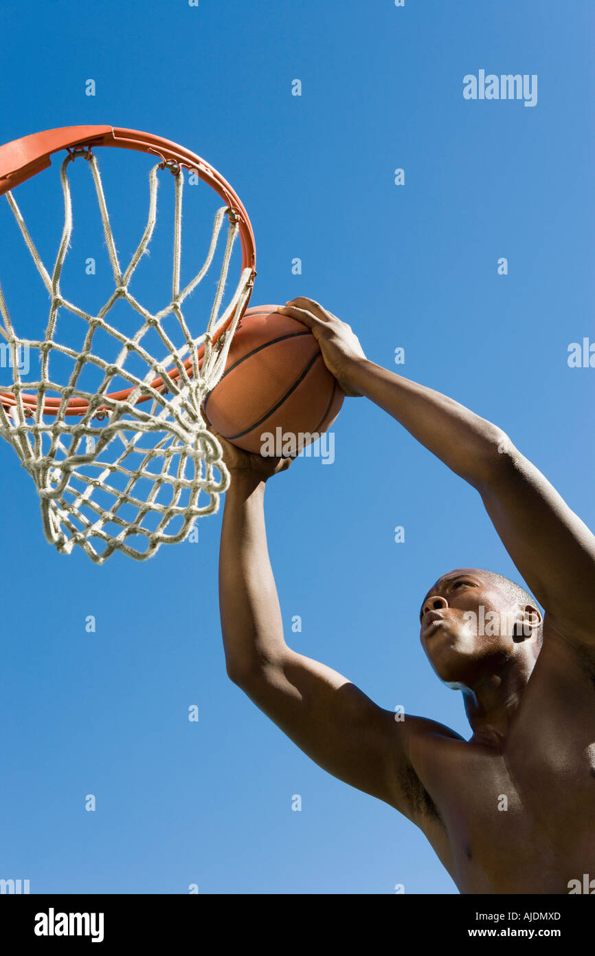 Basketball player slum dunking ball, low angle view Stock Photo - Alamy