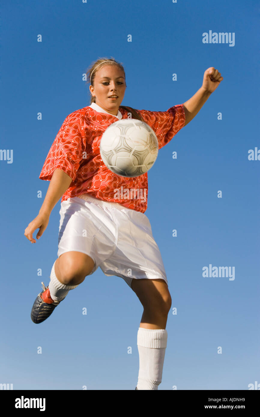 Girl (13-17) kicking soccer ball, portrait Stock Photo - Alamy