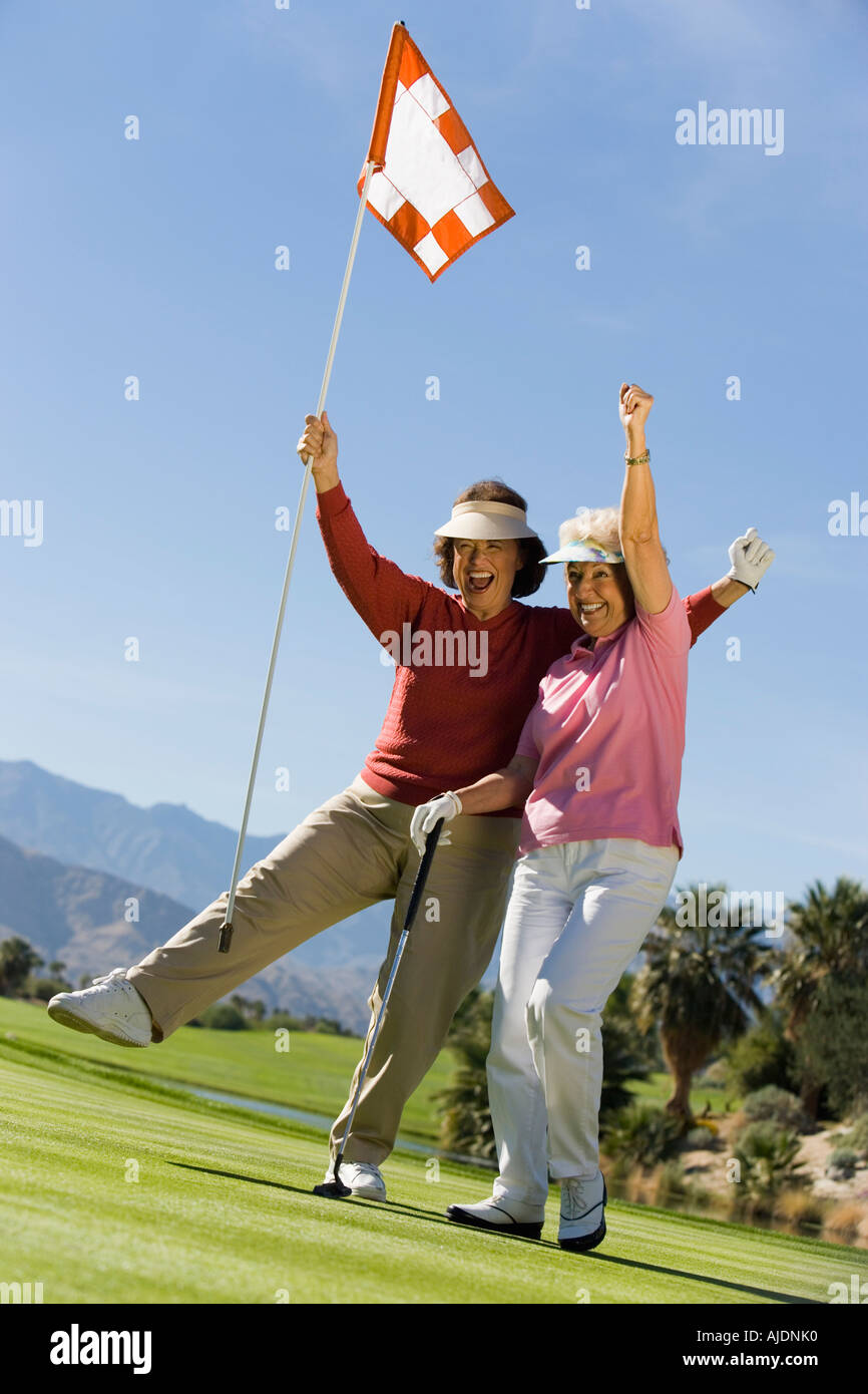 Two women cheering on golf course Stock Photo - Alamy