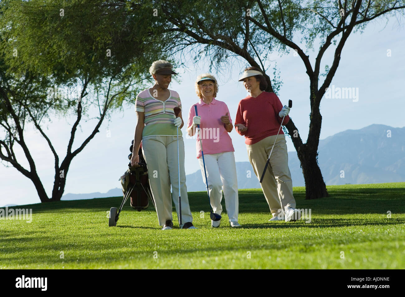 Three women walking on golf course Stock Photo - Alamy