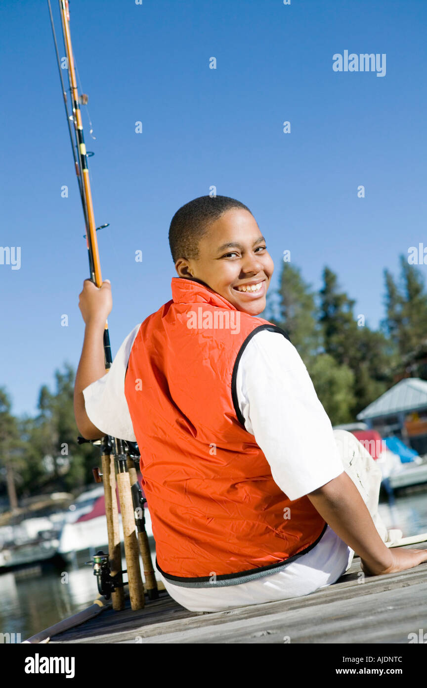 Boy fly fishing from pier, smiling, (portrait Stock Photo - Alamy