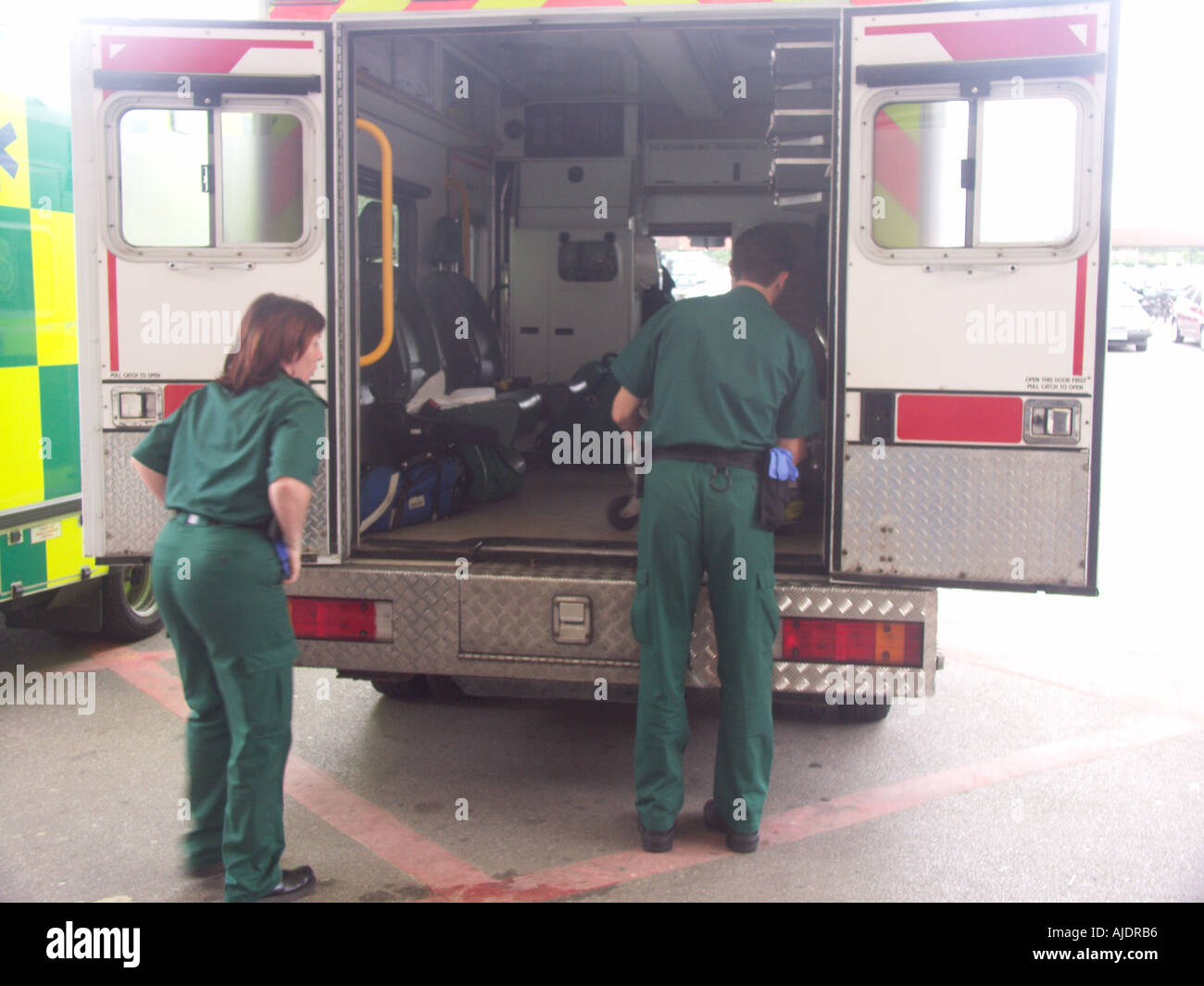 Male and female ambulance staff open back of ambulance Stock Photo - Alamy