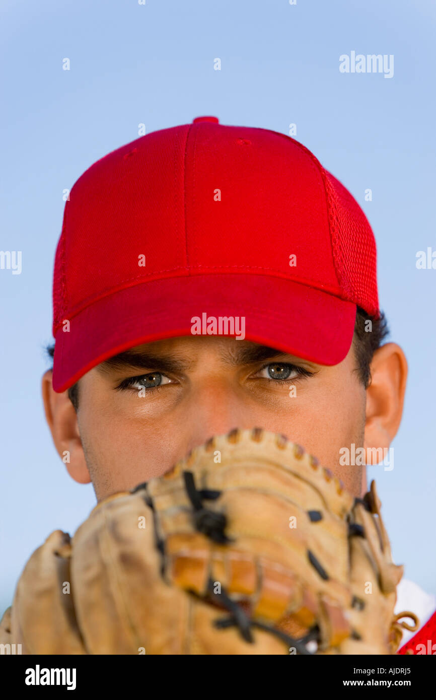 Baseball pitcher holding glove in front of face, (close-up), (portrait ...