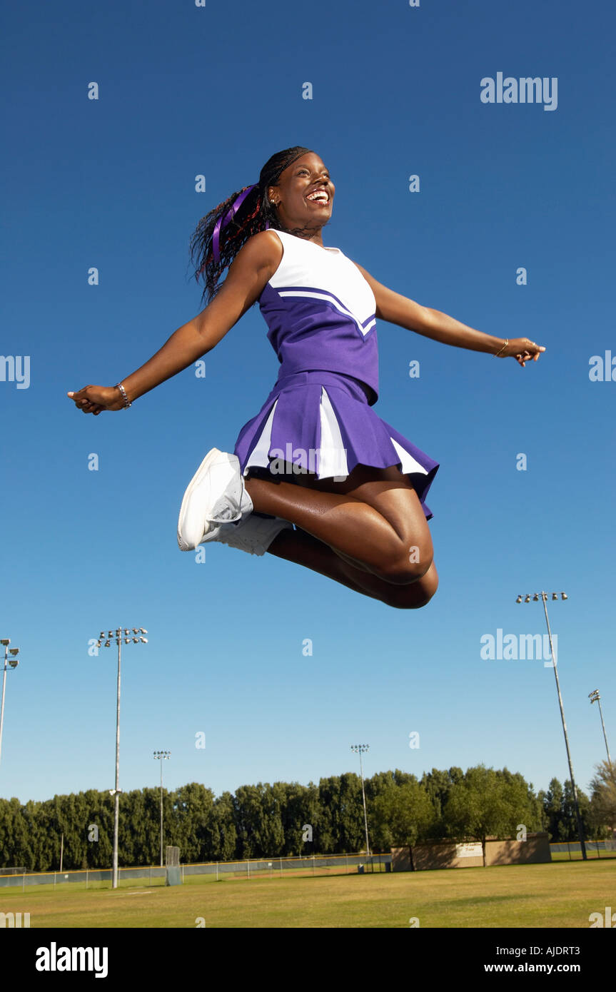 Cheerleader jumping on field, mid air, low angle view, (low angle view ...