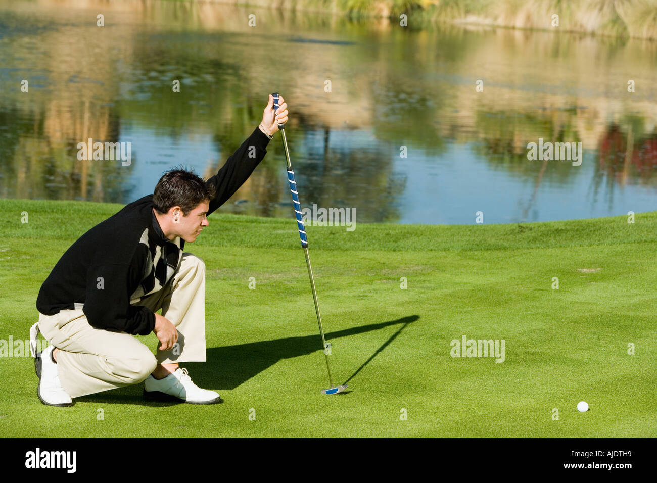 Golfer lining up putt Stock Photo - Alamy