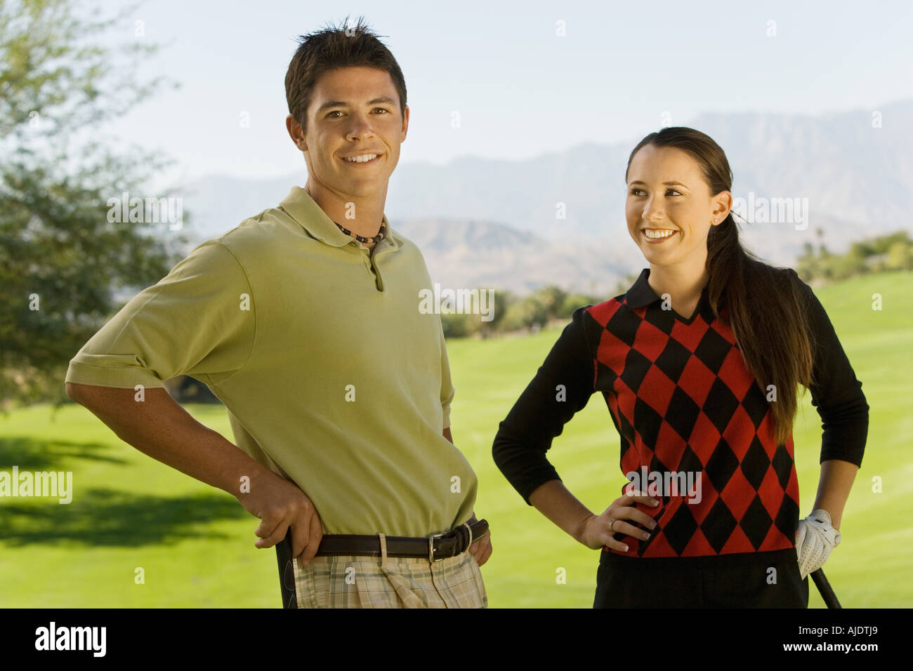 Couple of golfers standing together on golf course, (portrait Stock ...