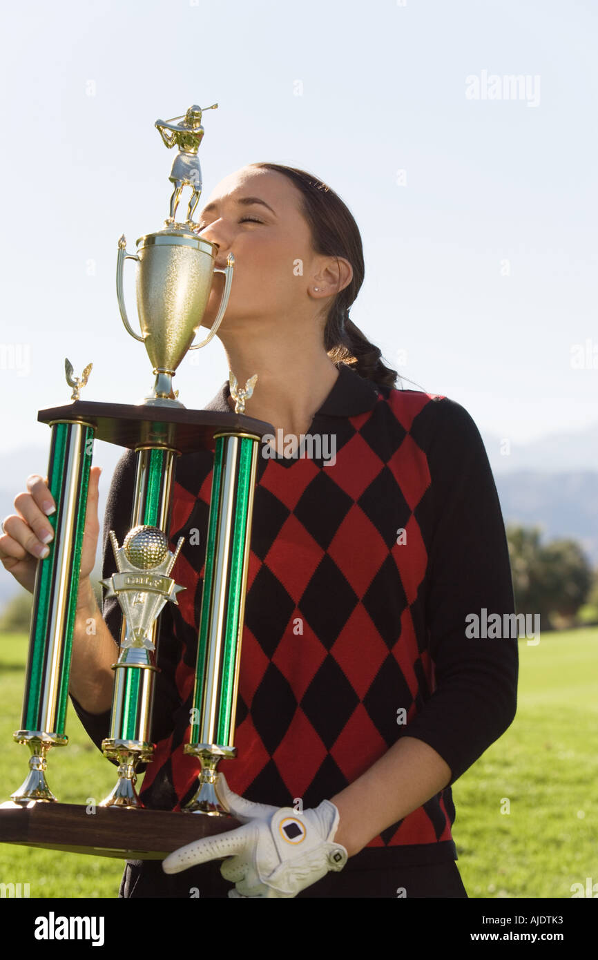 Female golfer kissing trophy Stock Photo - Alamy