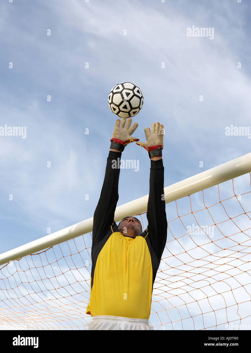 Goalkeeper reaching for ball Stock Photo - Alamy