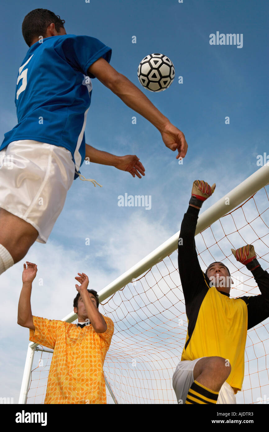 Soccer players jumping for ball Stock Photo - Alamy