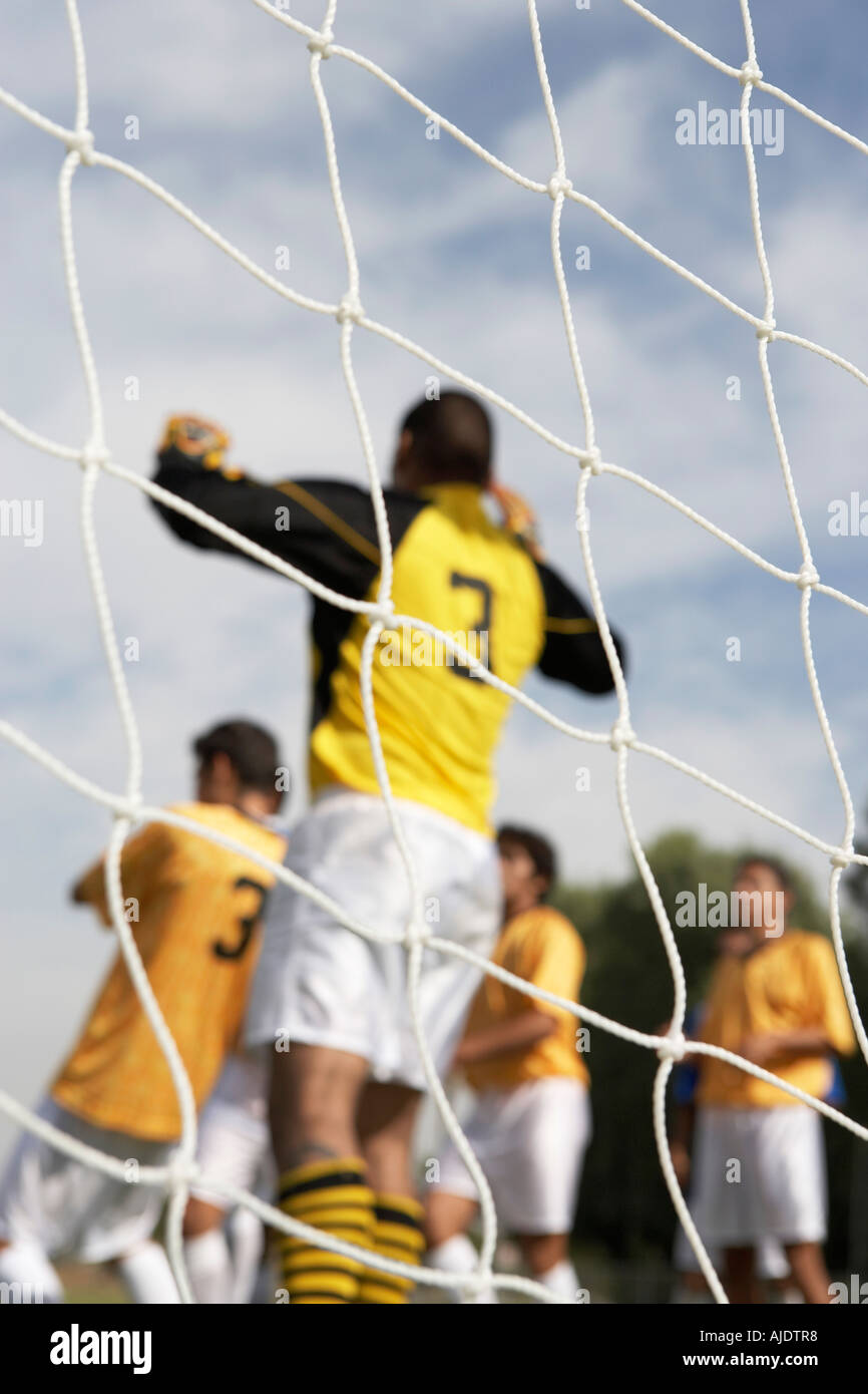 Goalkeeper jumping for soccer ball, back view Stock Photo - Alamy
