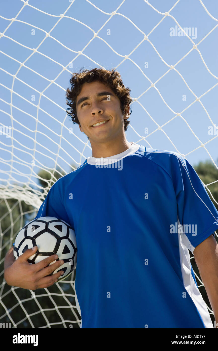 Soccer player standing in goal holding ball, portrait Stock Photo - Alamy