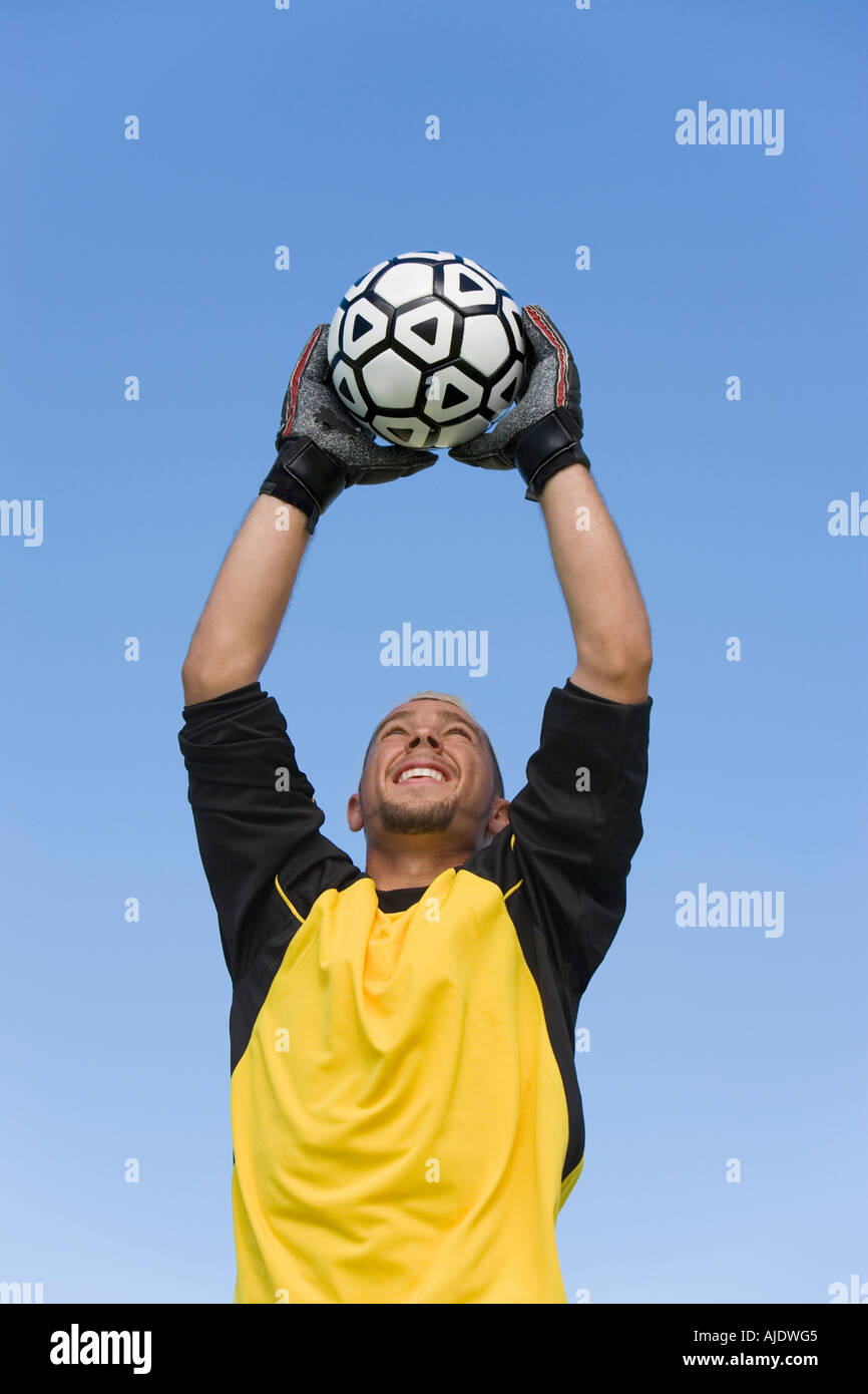 Goalkeeper catching soccer ball, portrait Stock Photo - Alamy