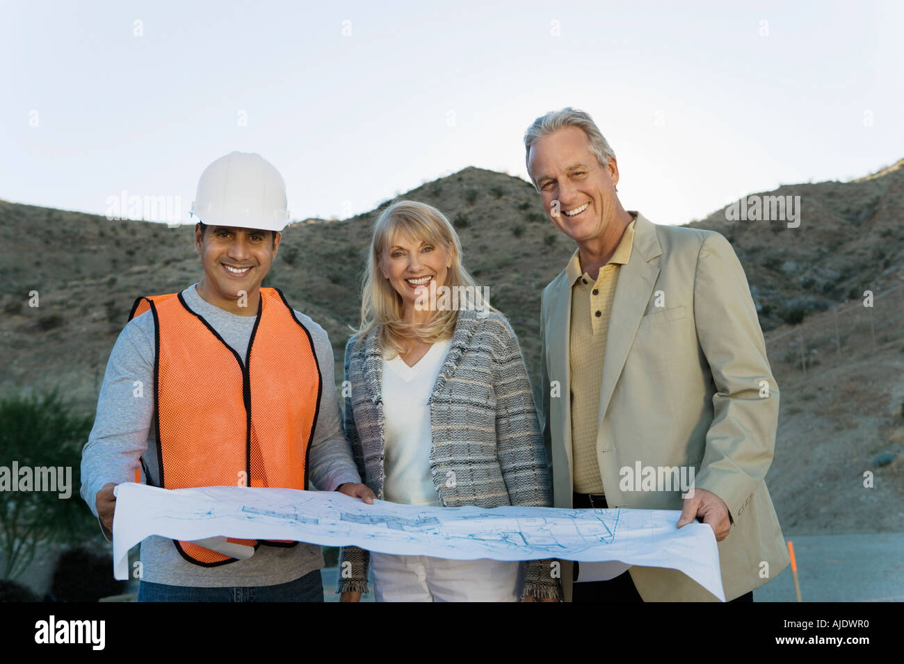 Builder with couple and blueprint for new home, portrait Stock Photo ...