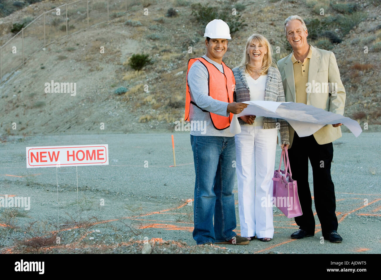 Builder and couple at new home construction site, portrait Stock Photo ...
