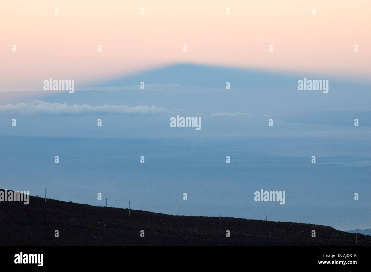 Sunrise and mountain shadow with view of West Maui and Lanai seen from ...