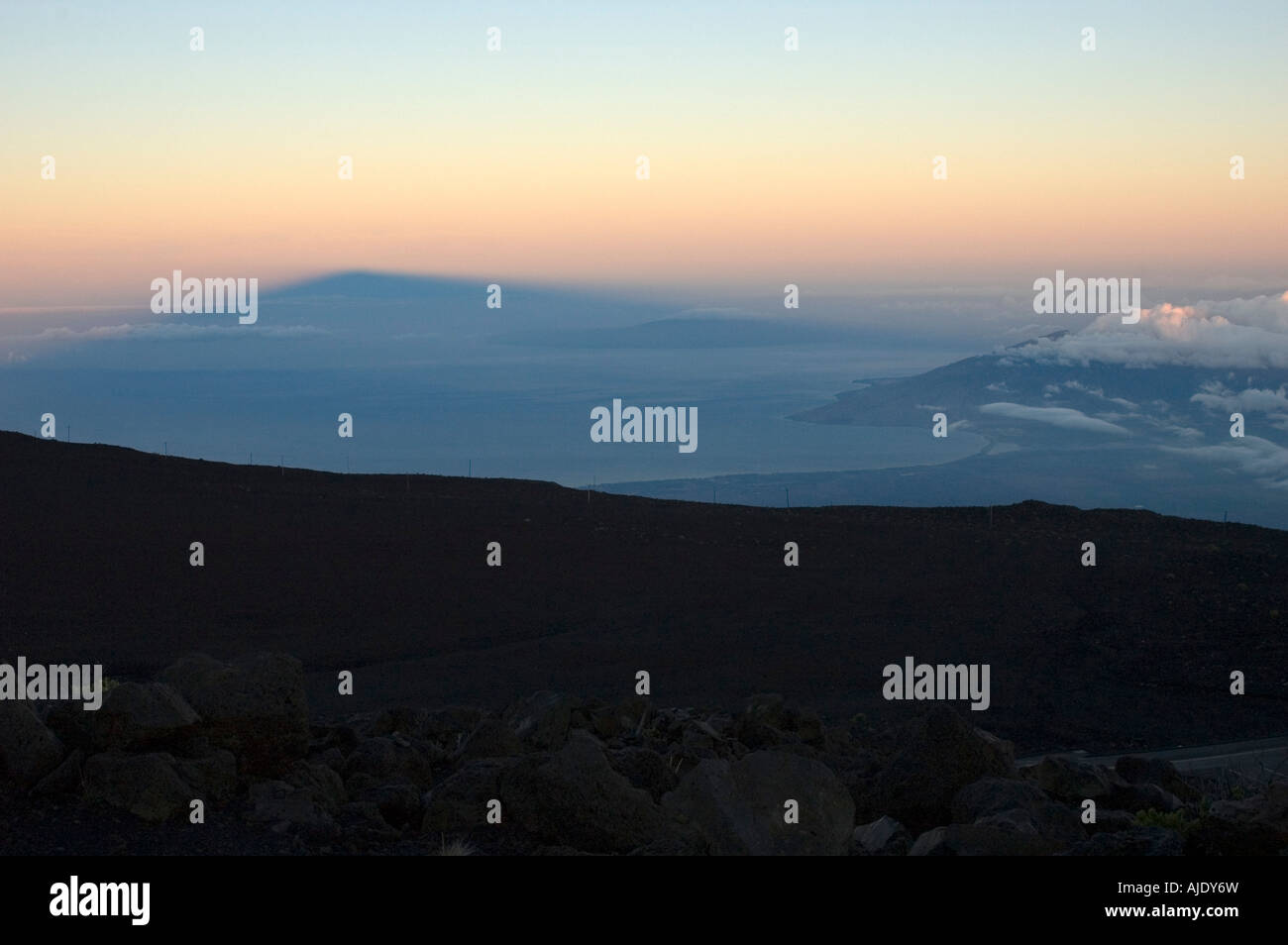 Sunrise and mountain shadow with view of West Maui and Lanai seen from ...