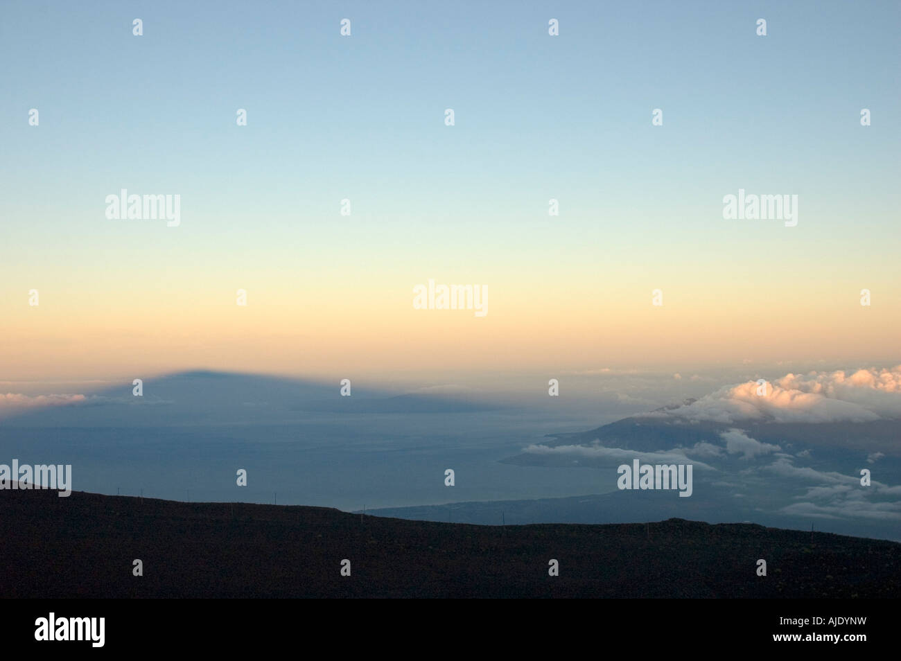Sunrise and mountain shadow with view of West Maui and Lanai seen from ...