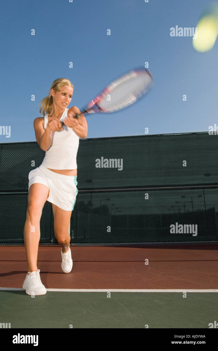 Tennis Player Hitting Backhand on tennis court Stock Photo - Alamy