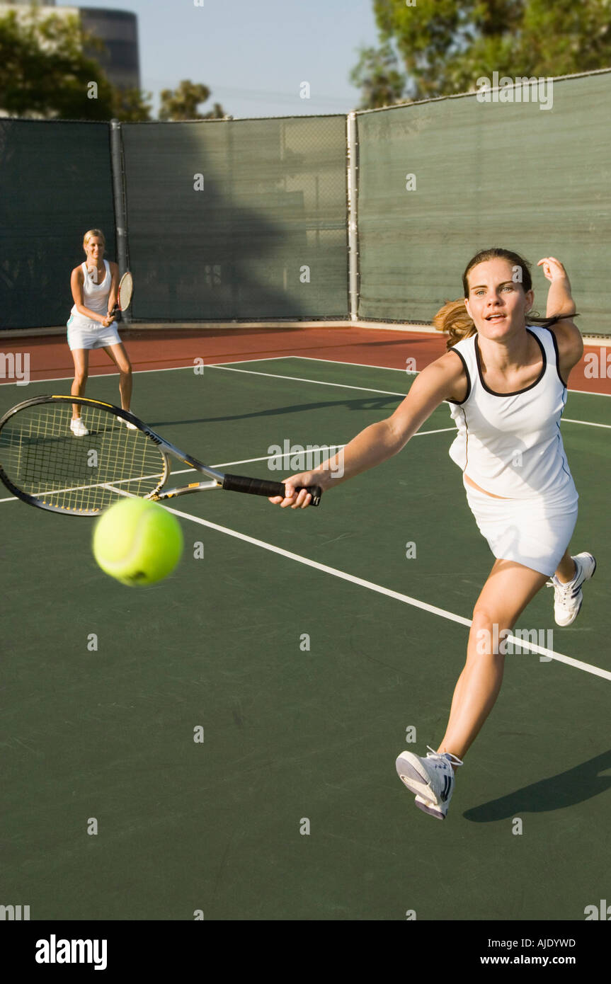 Tennis Player Reaching to hit tennis ball on tennis court Stock Photo ...