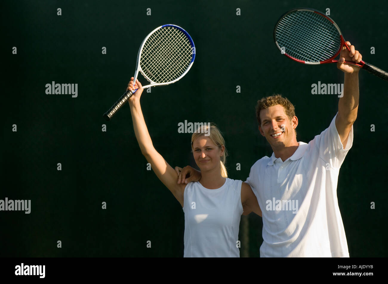 Standing holding smiling tennis racket arm around hi-res stock ...