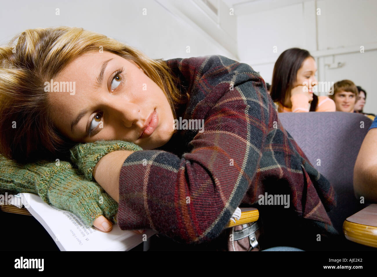Female student resting on textbook during class Stock Photo - Alamy