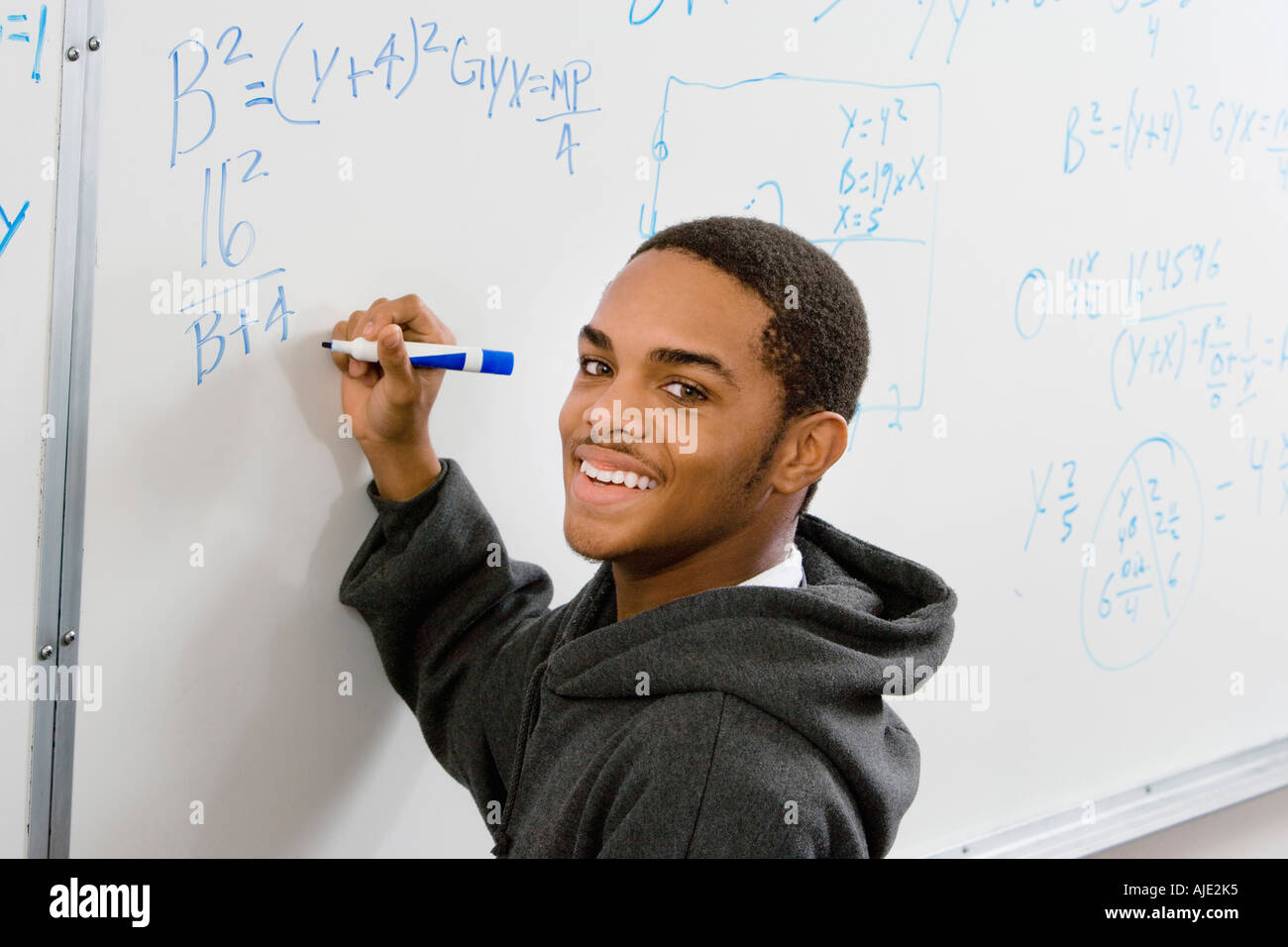 Male student writing equations on whiteboard, (portrait Stock Photo - Alamy