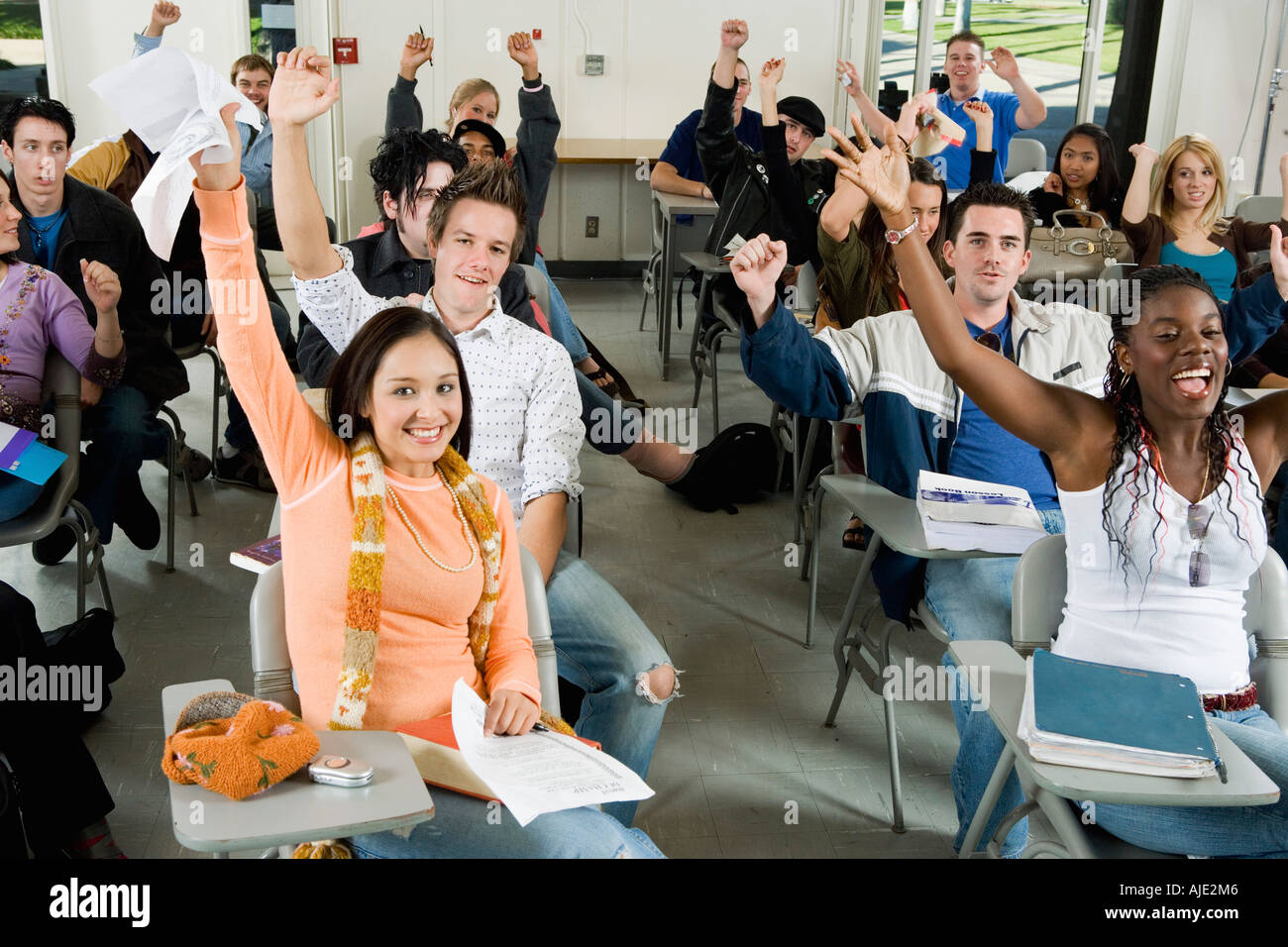 Students raising hands in classroom Stock Photo - Alamy