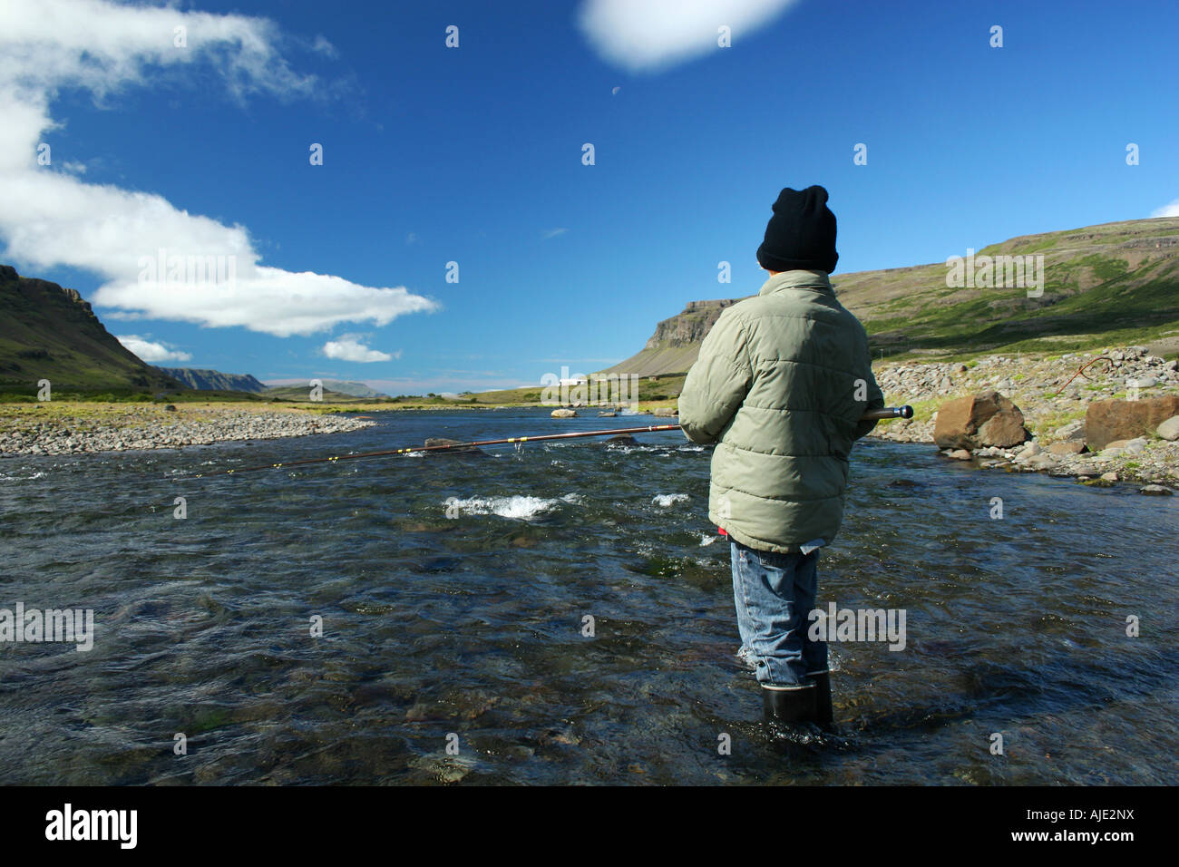 a young boy fishing in a great north atlantic salmon river waiting for ...
