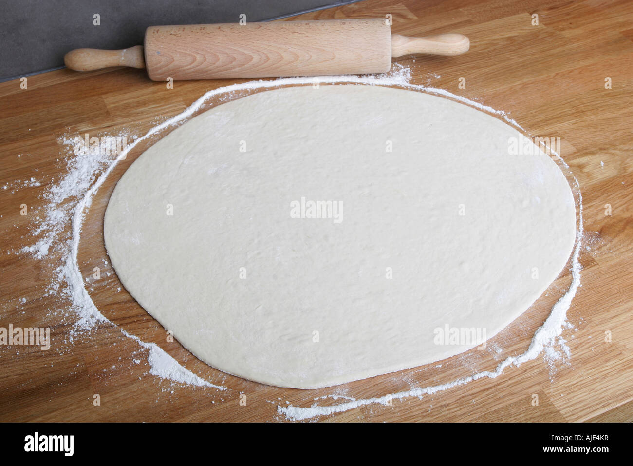 homemade pizza on wooden kitchen counter with rolling pin Stock Photo ...
