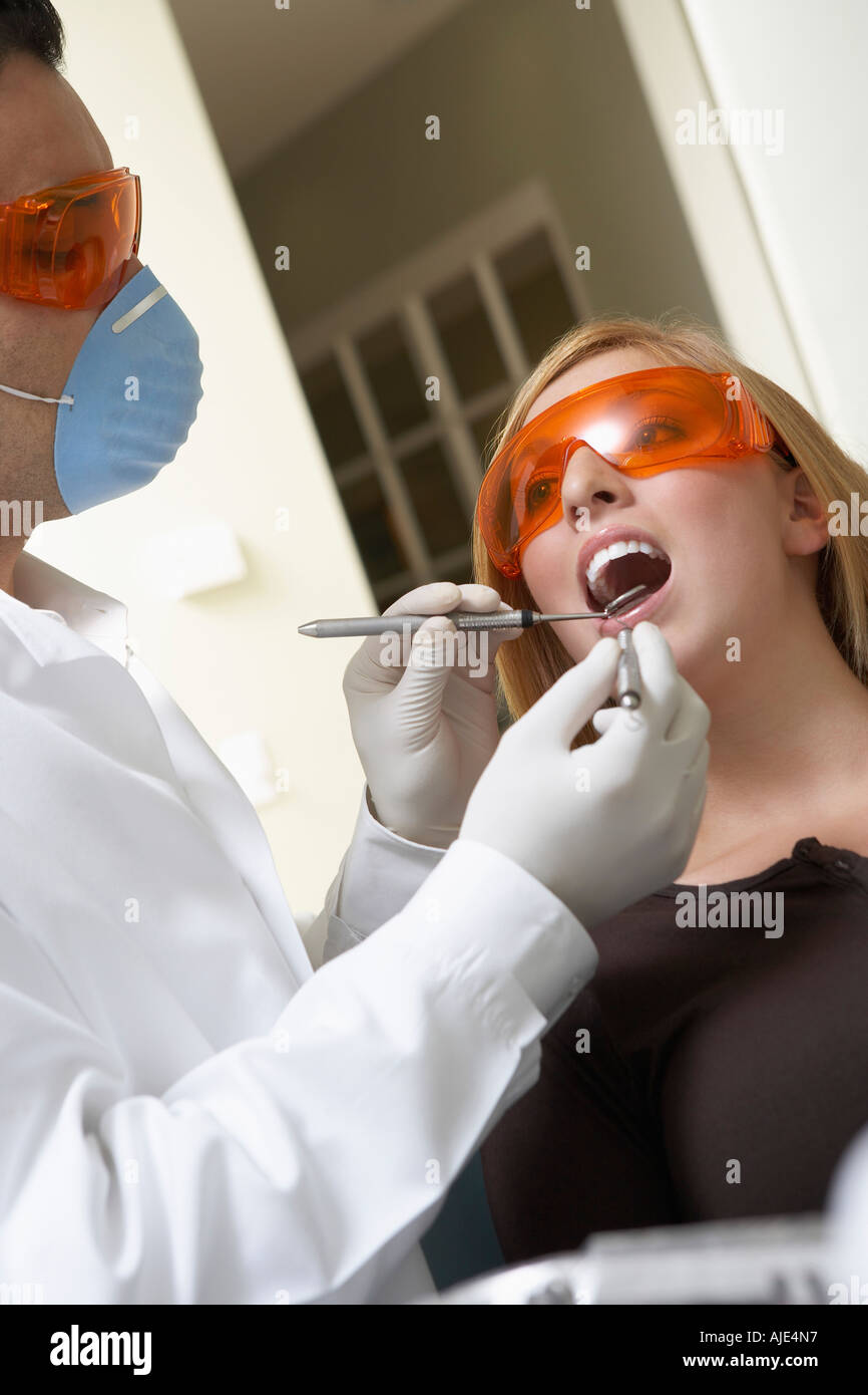 Dentist examining womans teeth in surgery Stock Photo - Alamy
