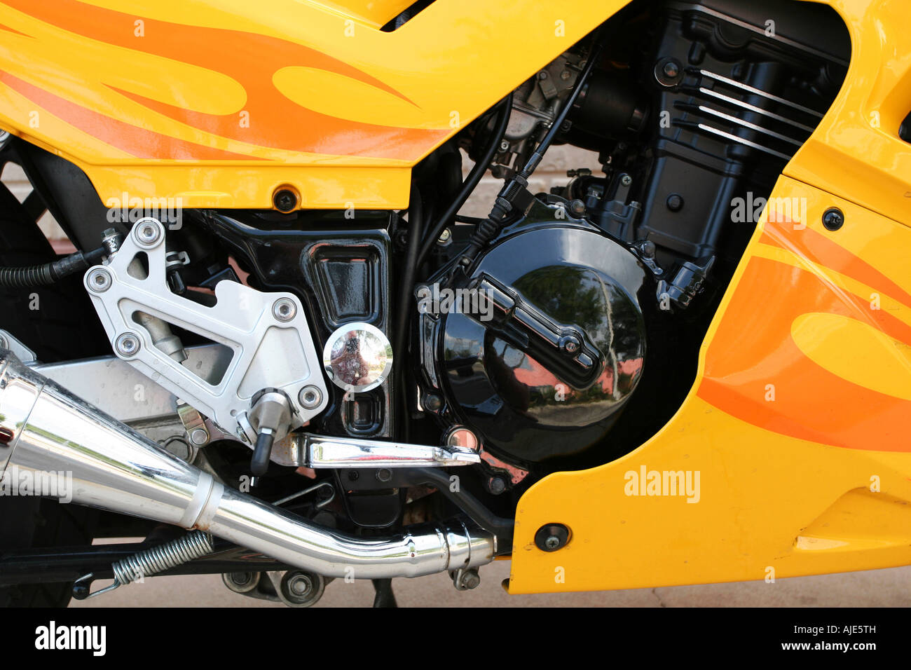 A cropped shot of a motorcycle engine on a yellow bike Stock Photo - Alamy