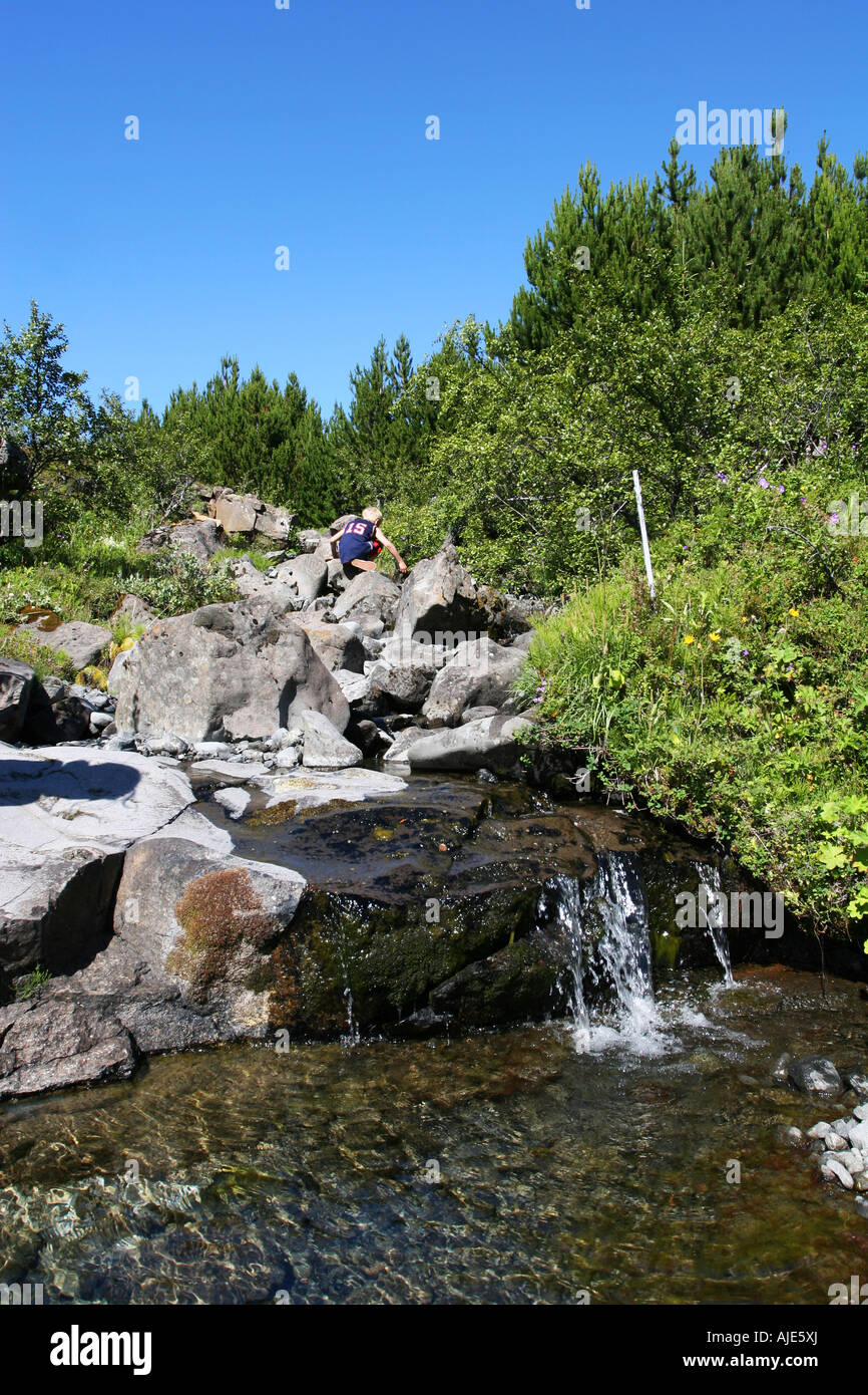 young boy climbing over rocks in a mountain spring Stock Photo - Alamy