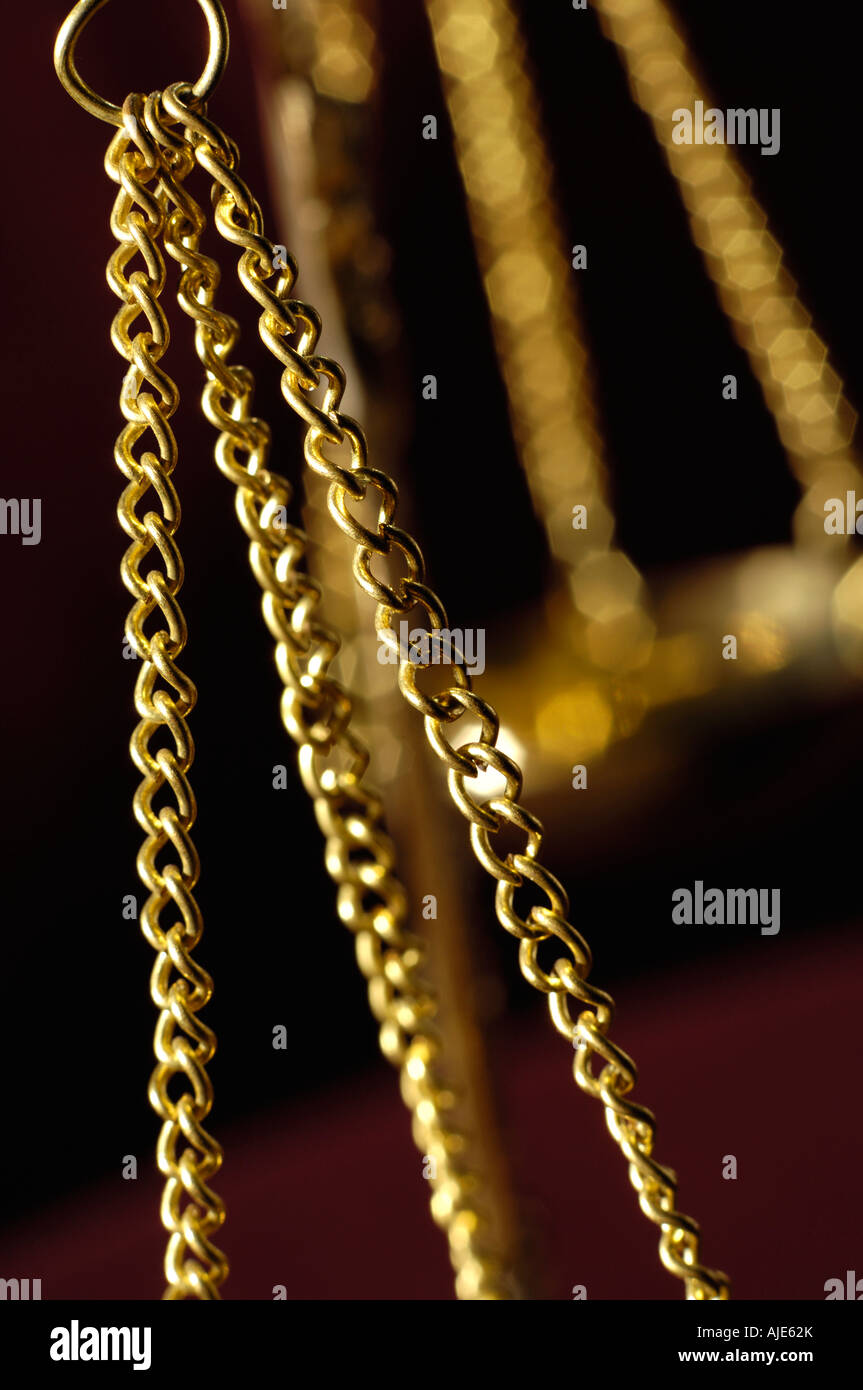 Shiny golden scales of justice chains close up on dark red Stock Photo ...