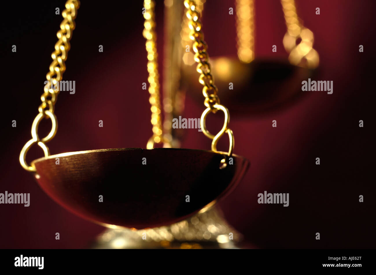 Shiny golden empty unbalanced vintage justice scales close up on dark ...