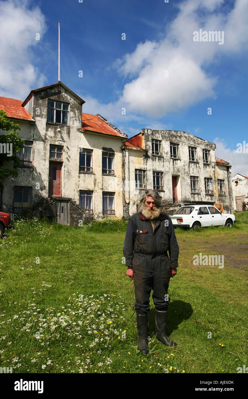 A desolate old farm in bad shape with the old farmer standing out front ...