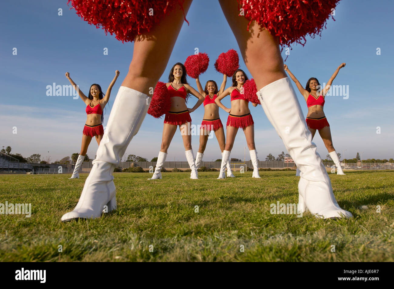 Cheerleader in white knee high boots, low section with cheerleaders ...