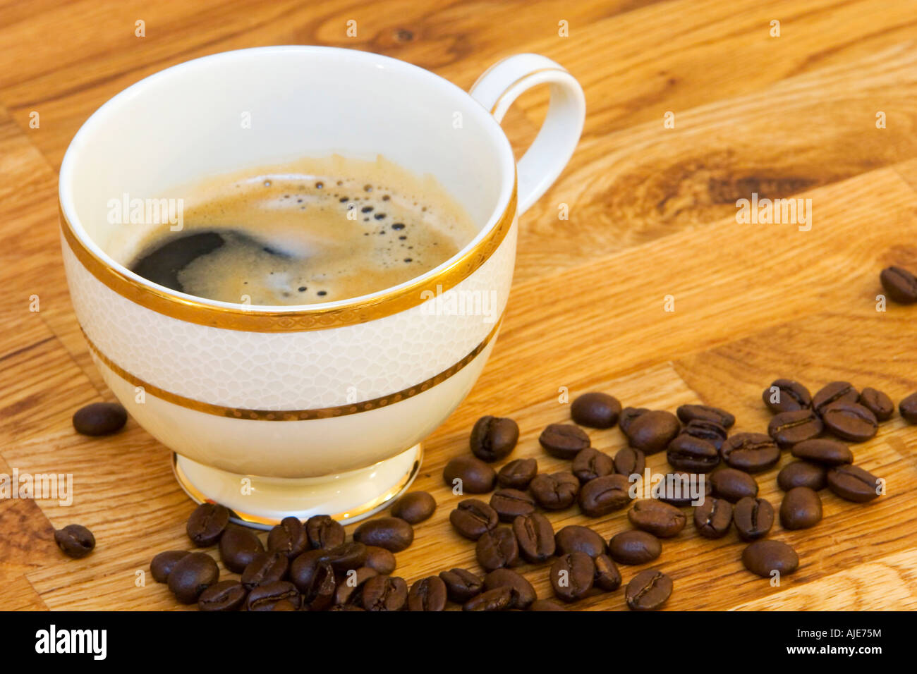 coffee cup on natural wood foaming coffee in cup and coffeebeans lying ...